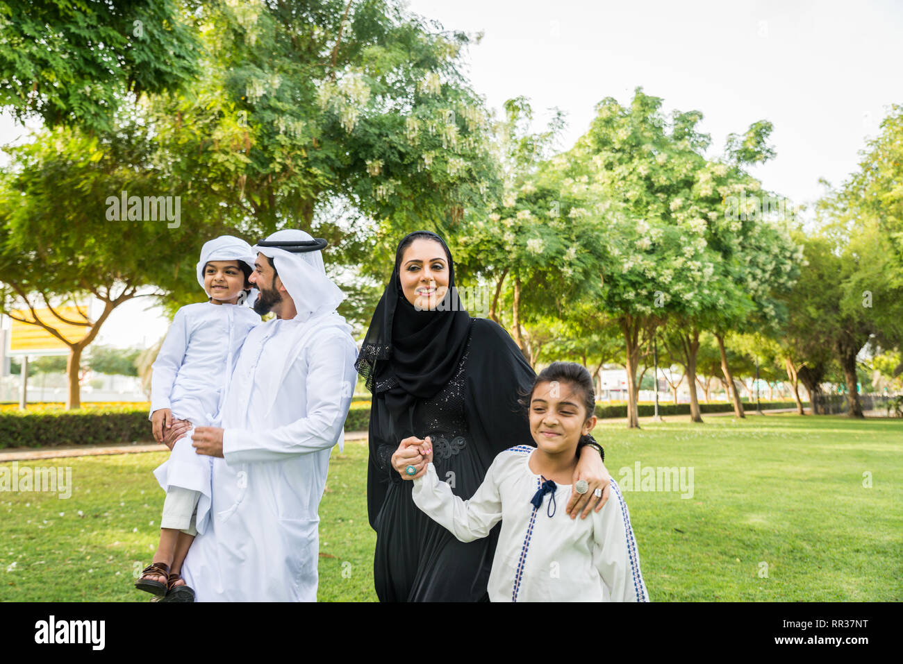 Happy middle-eastern family having fun in a park in Dubai - Parents and ...