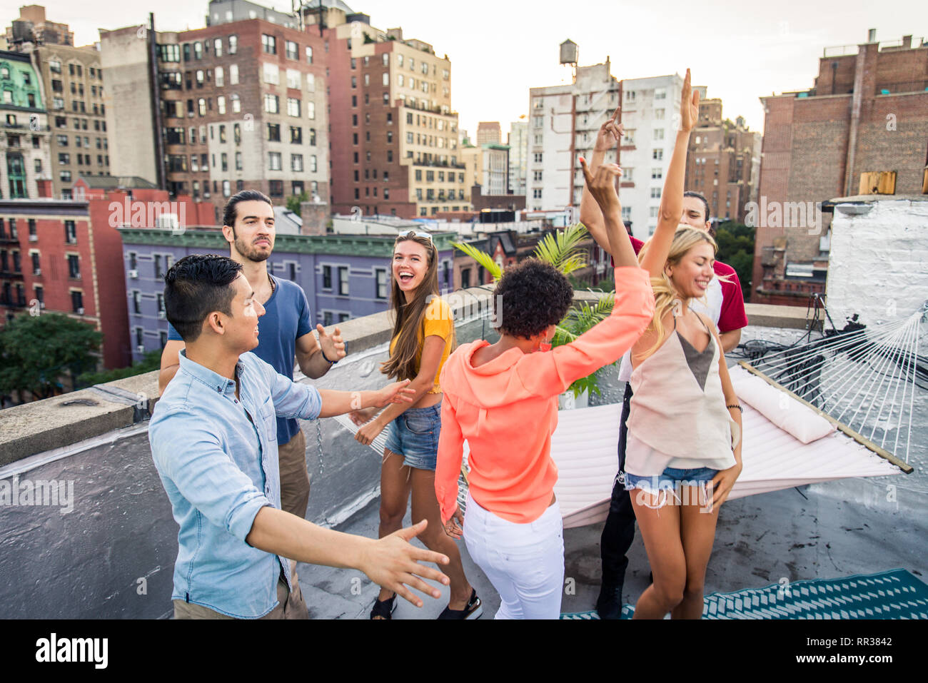 Young happy people having a barbecue dinner on a rooftop in New York ...
