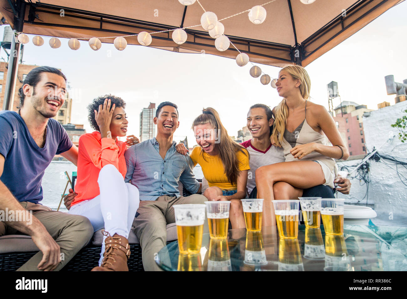 Young happy people having a barbecue dinner on a rooftop in New York ...