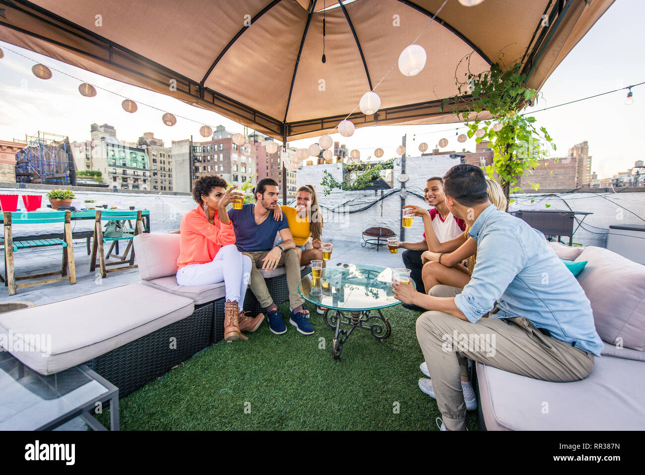 Young happy people having a barbecue dinner on a rooftop in New York ...