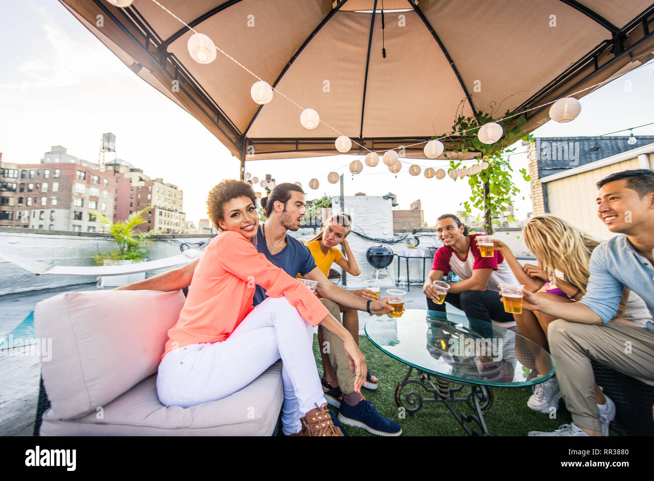 Young happy people having a barbecue dinner on a rooftop in New York ...