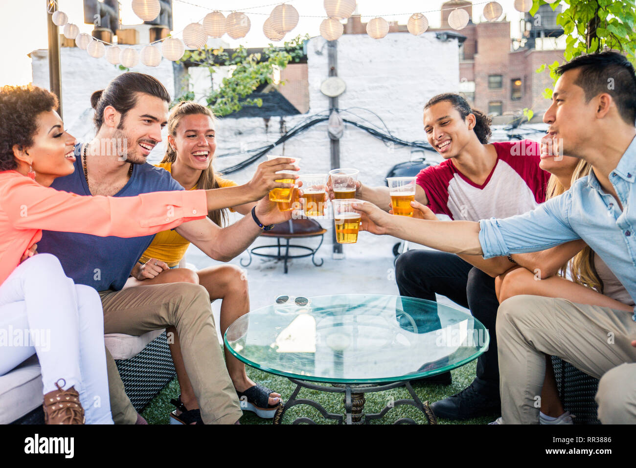 Young happy people having a barbecue dinner on a rooftop in New York ...
