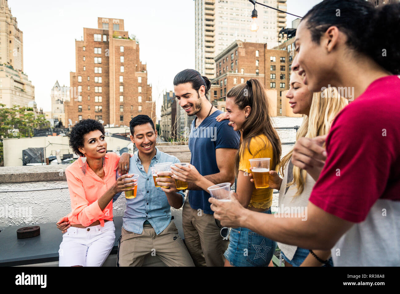 Young happy people having a barbecue dinner on a rooftop in New York ...