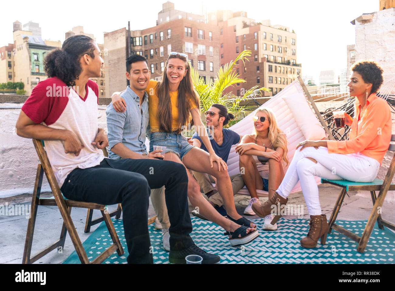 Young happy people having a barbecue dinner on a rooftop in New York ...