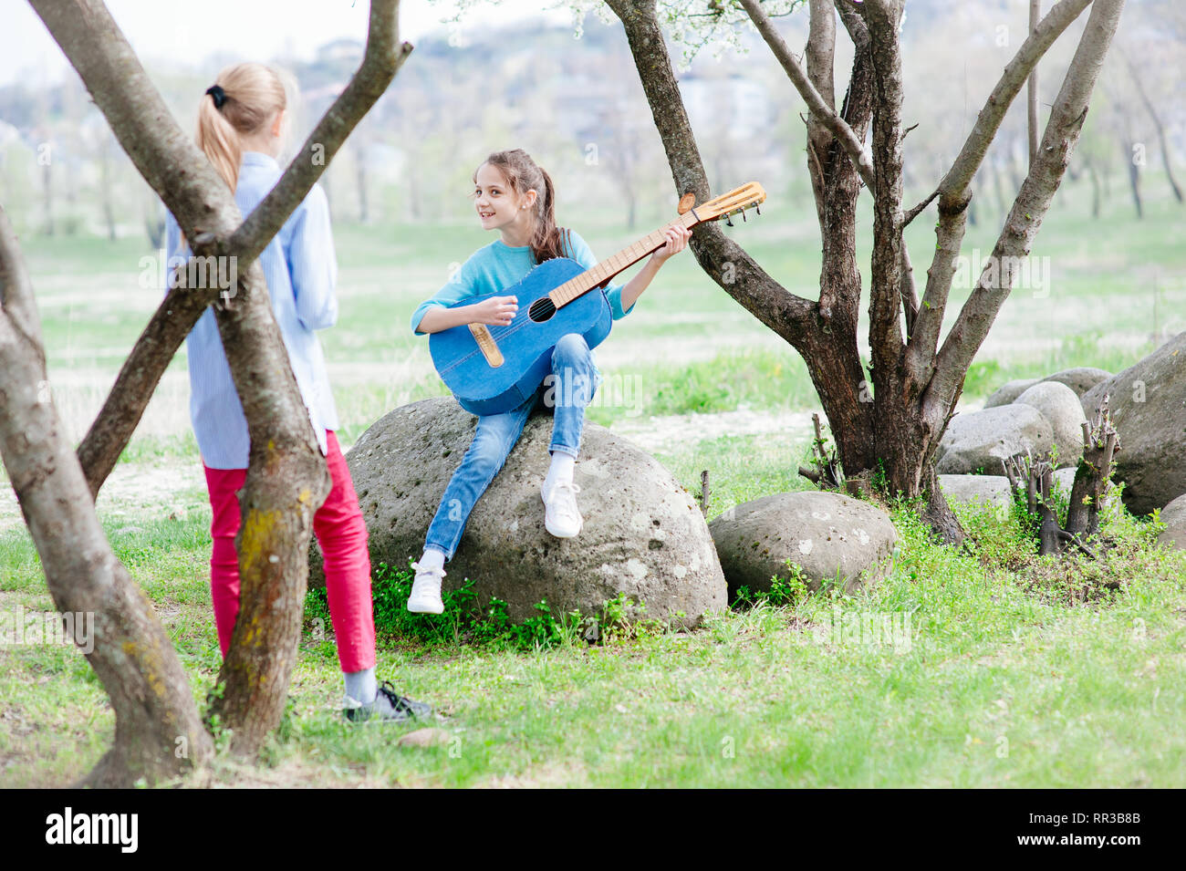music concept of two young caucasian girls playing guitar and singing ...