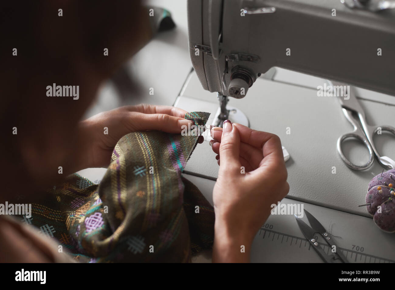 Tailor workplace: scissors, needles, electrical sewing machine and ...