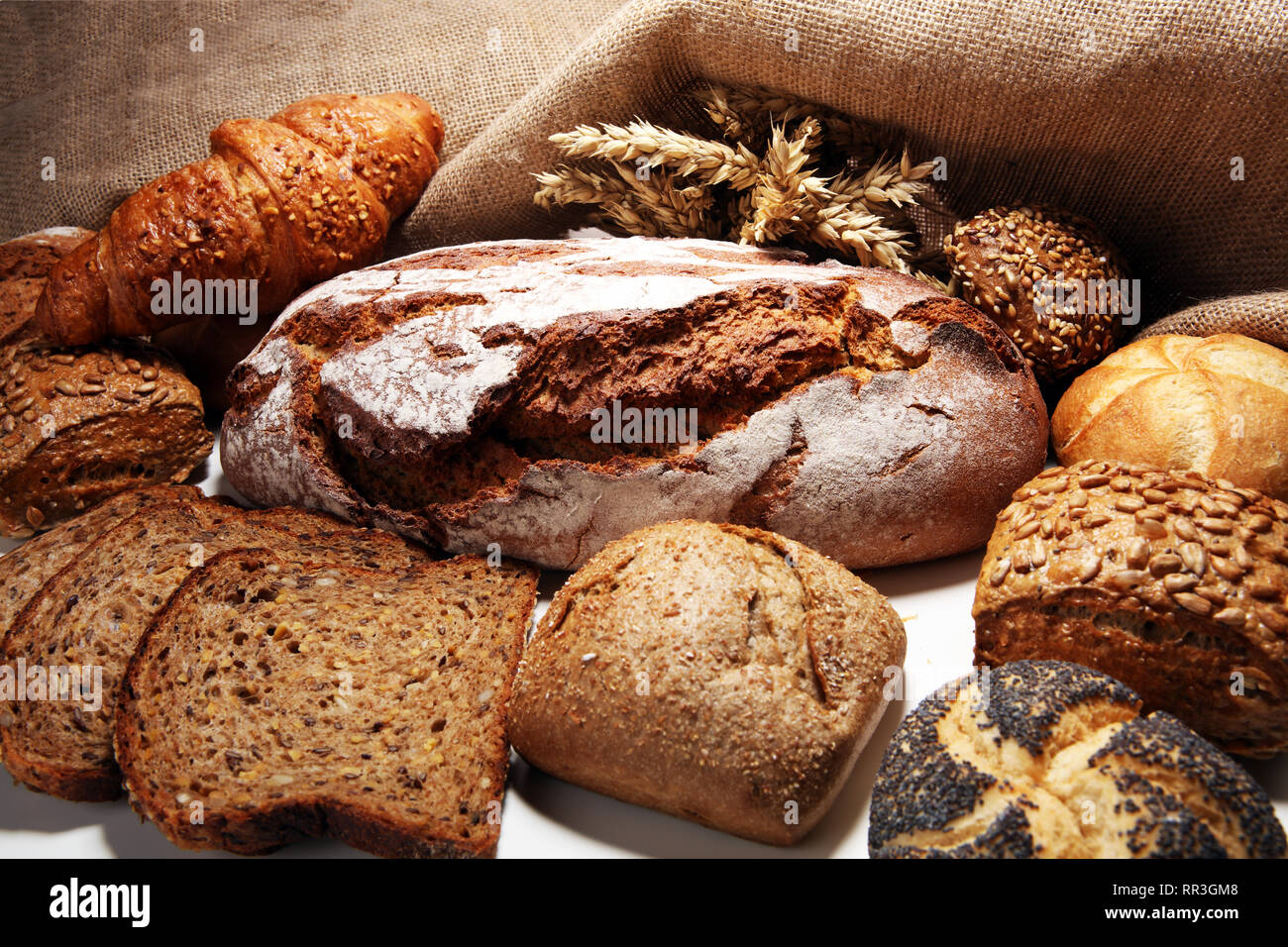 Different kinds of bread and bread rolls on board from above. Kitchen ...