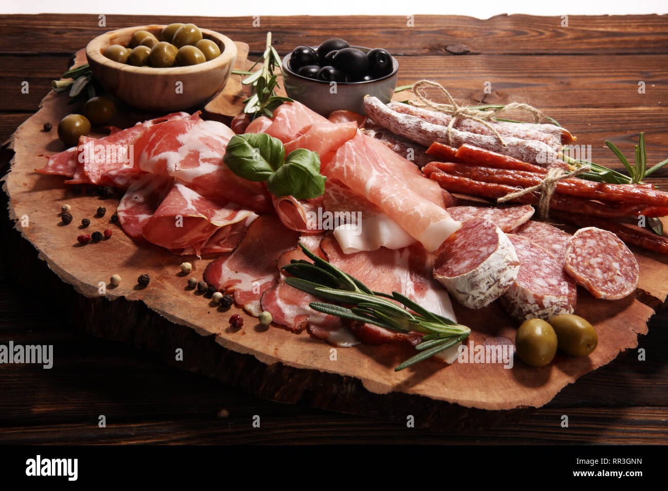 Marble cutting board with prosciutto, bacon, salami and sausages on ...