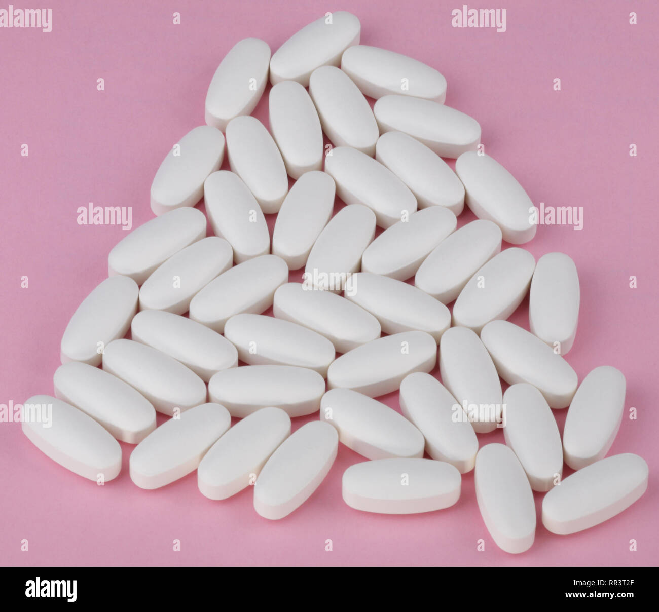 white pill on pink background Stock Photo - Alamy