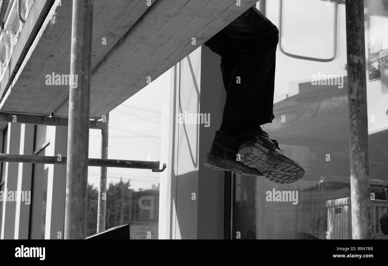 a man's legs who's doing building facade renovation works in Riga ...