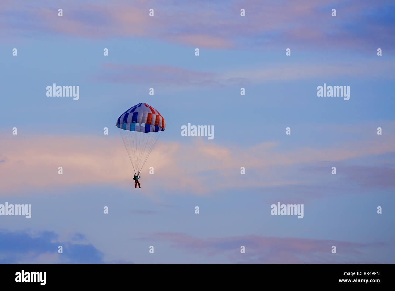 Parachutist falling from the sky in evening sunset dramatic sky ...