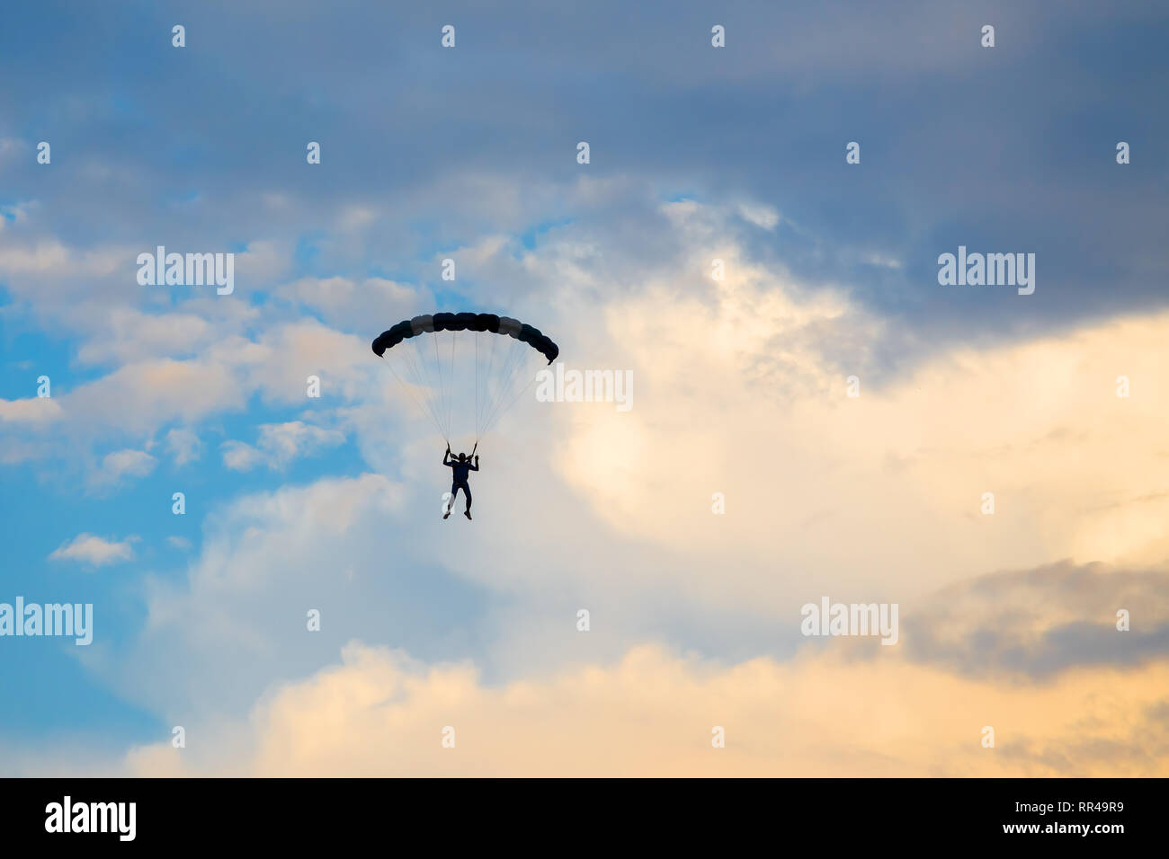 Parachutist falling from the sky in evening sunset dramatic sky ...