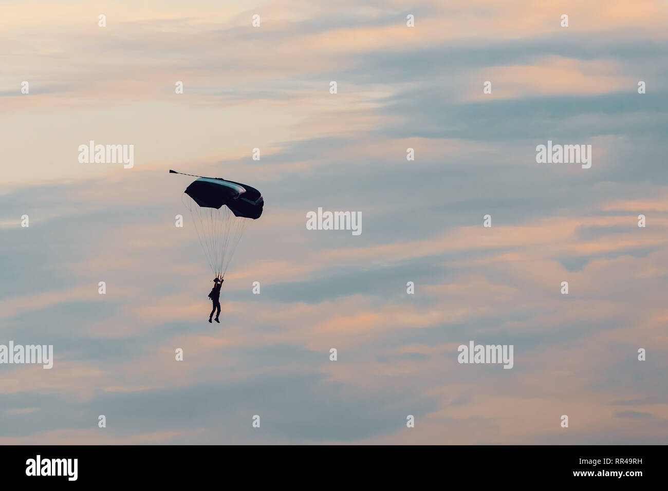 Parachutist falling from the sky in evening sunset dramatic sky ...