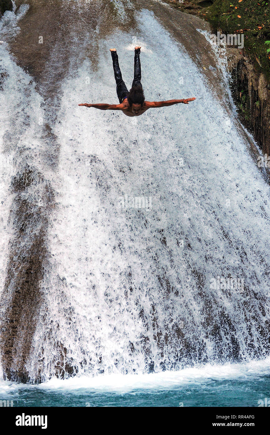 A man dives off Blue hole waterfall at Island Gully Falls near Ocho ...