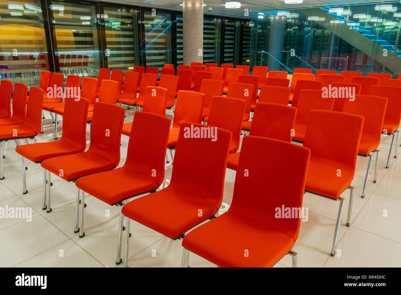 Red chairs aligned in rows in conference room Stock Photo - Alamy