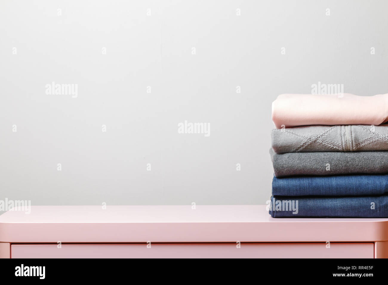 Cotton stack of colorful folded clothes on white table indoors empty ...