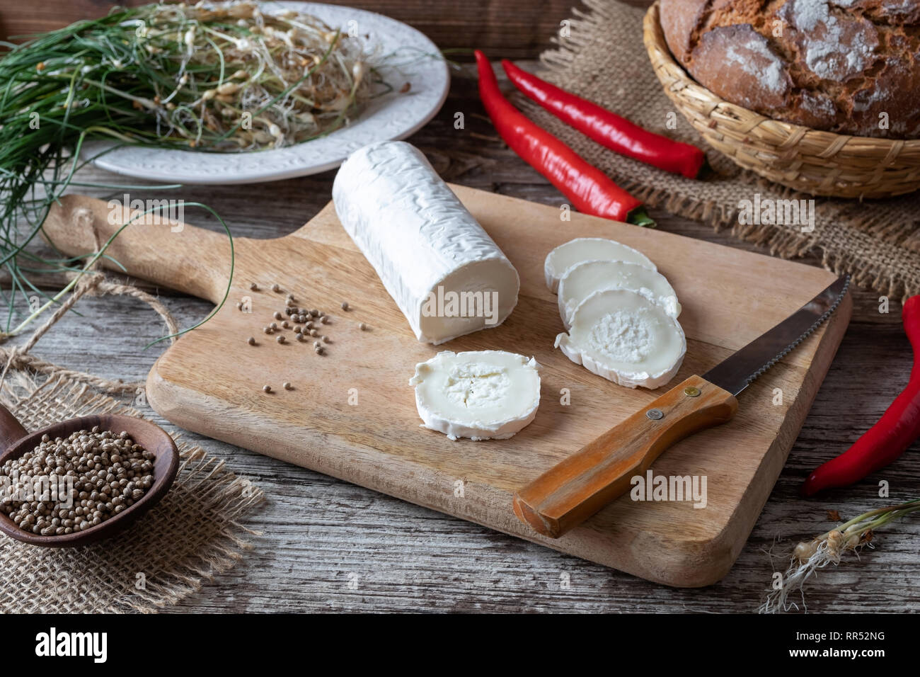Cutting goat cheese before pickling it with crow garlic, hot peppers ...