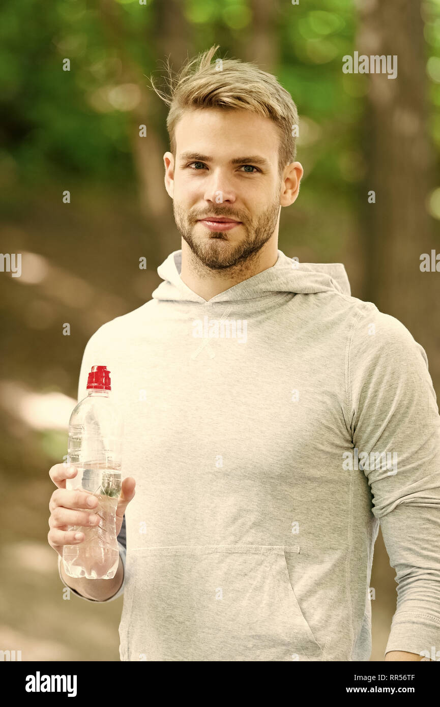 Drink some water. Man handsome jogger holds water bottle whole workout ...