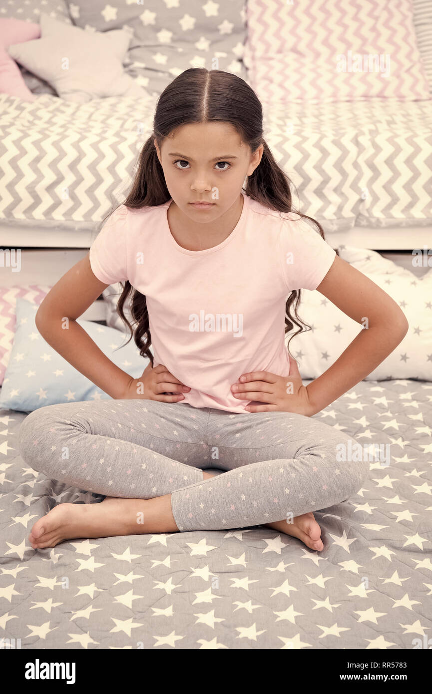 Do not disturb child before sleep. Girl child sit on bed in her bedroom ...