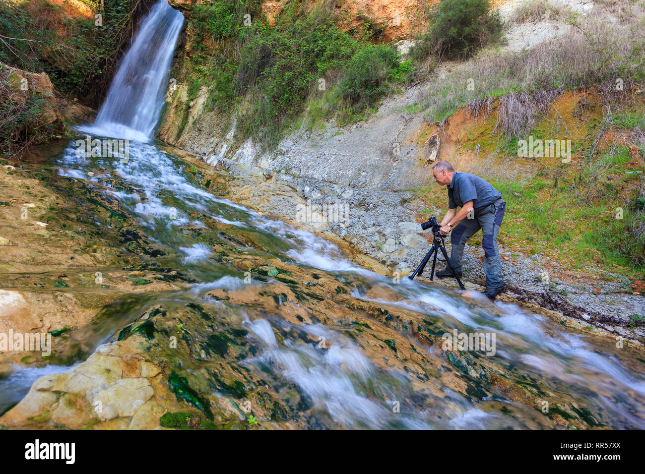 Photographer at waterfall at the start of Albaida river, in Atzeneta de ...