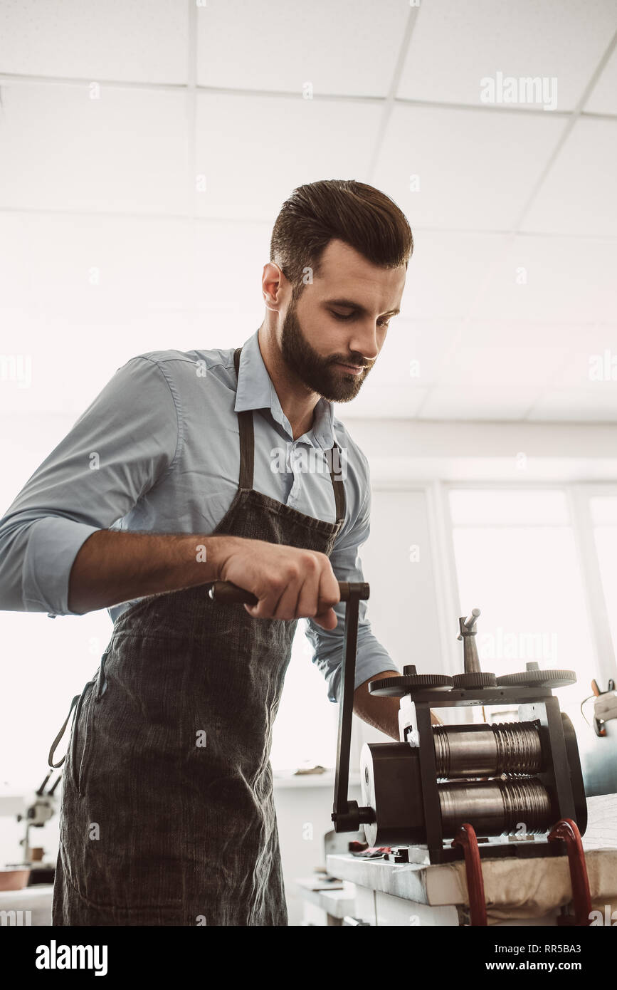 Old technologies. Vertical photo of young male goldsmith crafting metal ...