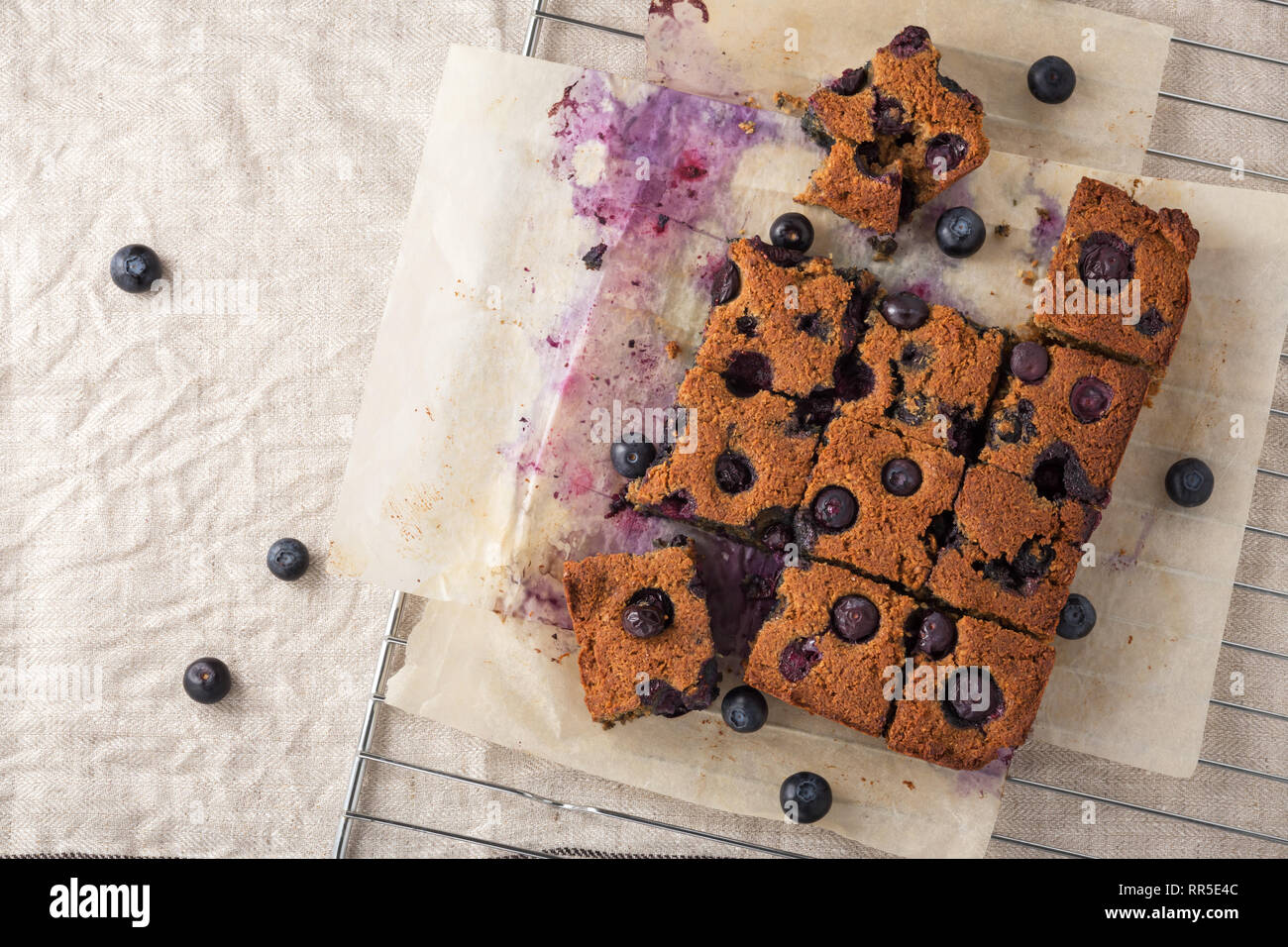 Blueberry square bars on paper baking sheet with blueberries, paleo low ...