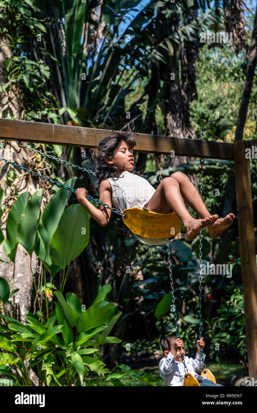 latin child playing on swing in Guatemalan playground Stock Photo - Alamy