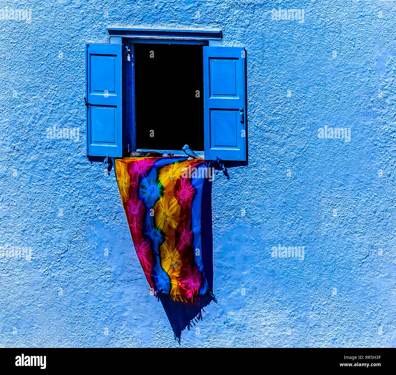 Open Window. Blue coloured open window with a colourful rug hanging ...