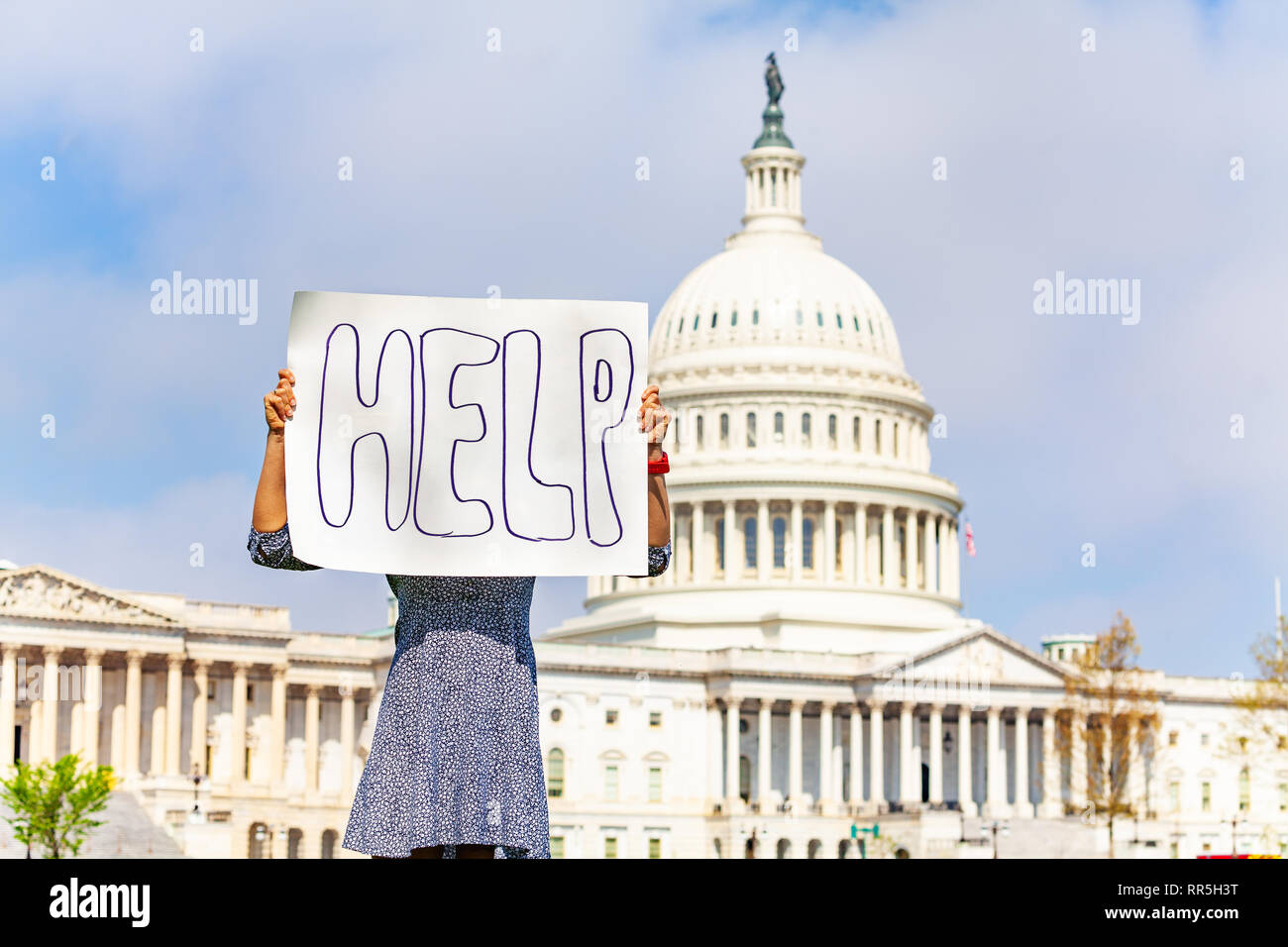 Protester holding sign in hands asking for help Stock Photo - Alamy