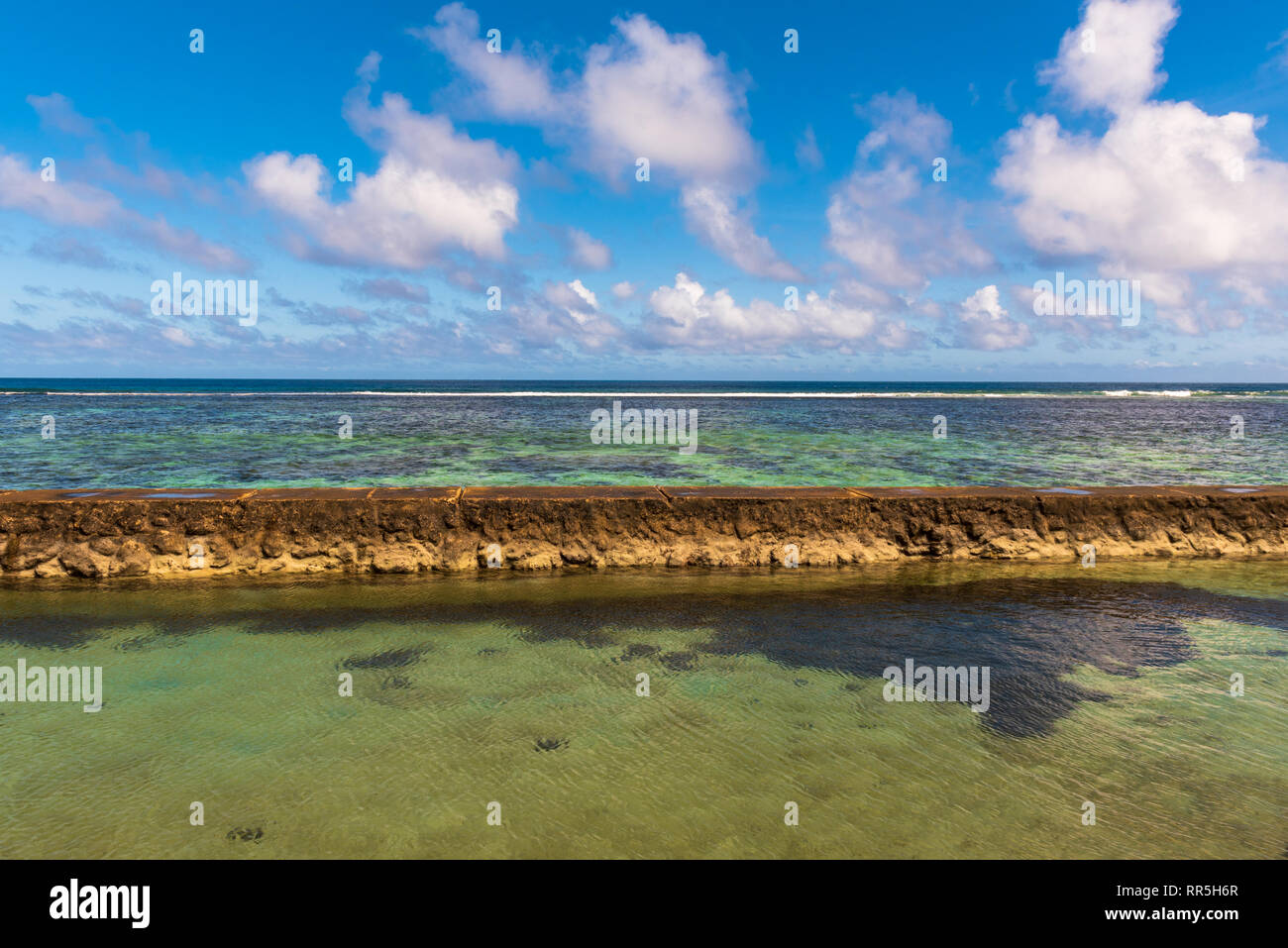 Wide angle shot of a sea wall, blue sky and the horizon as seen from ...