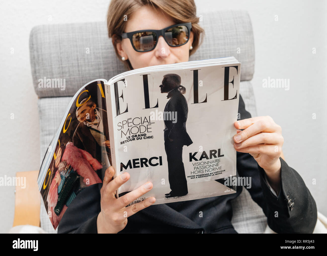Paris, France - Feb 23, 2019: Young woman reading French Elle magazine ...