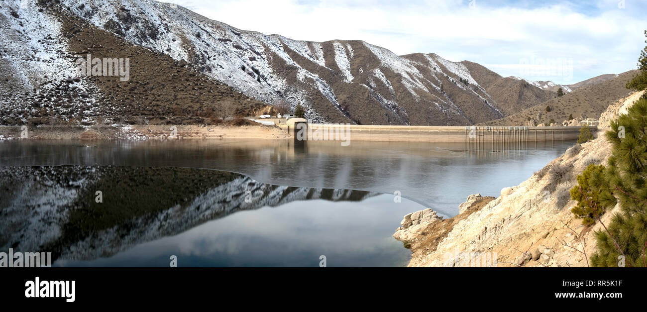 Winter snow reflect from the mountains beyond at a Hydroelectric Dam in ...