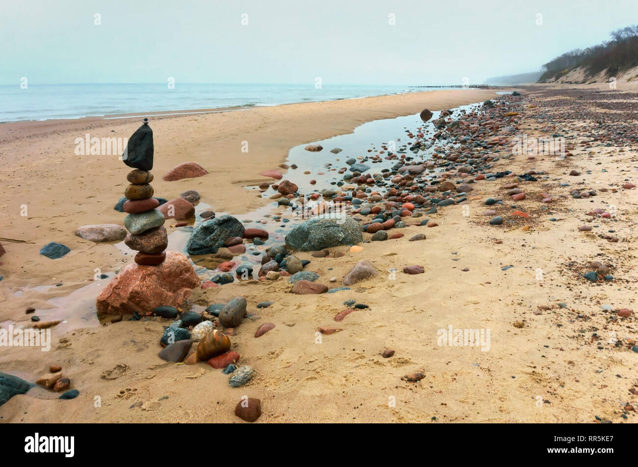 pyramid of sea stones, cloudy sea shore Stock Photo - Alamy