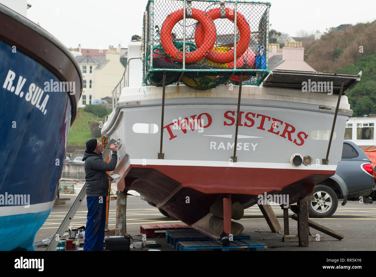 Sailor mantaining he's fishing boat Port Erin Stock Photo - Alamy