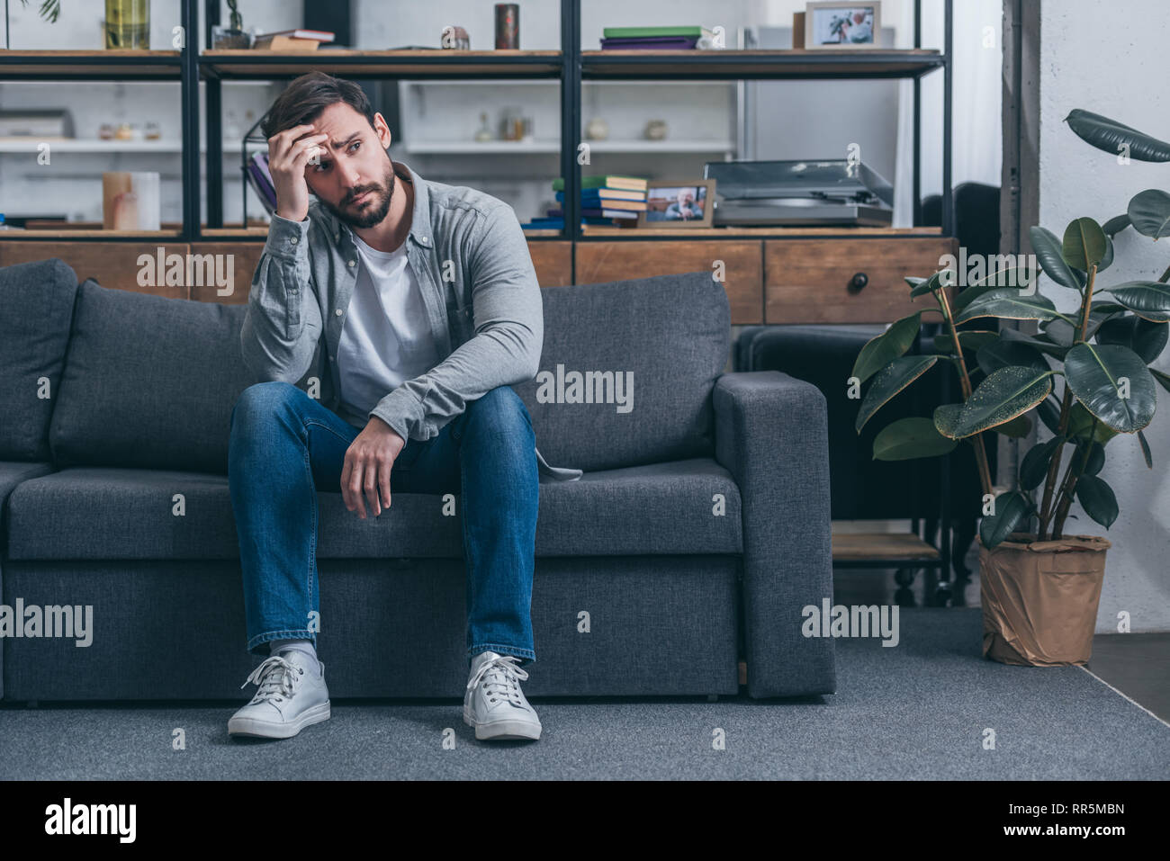 Depressed sad man on couch hi-res stock photography and images - Alamy