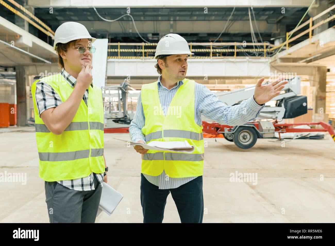 Male building workers working at construction site. Building ...