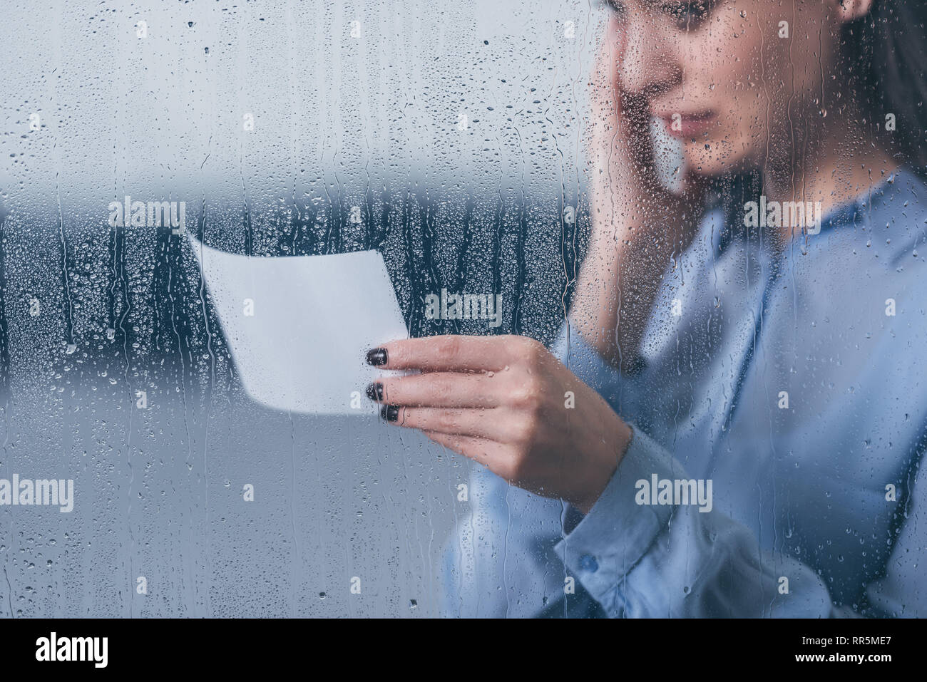 cropped view of grieving woman holding photograph and crying through ...
