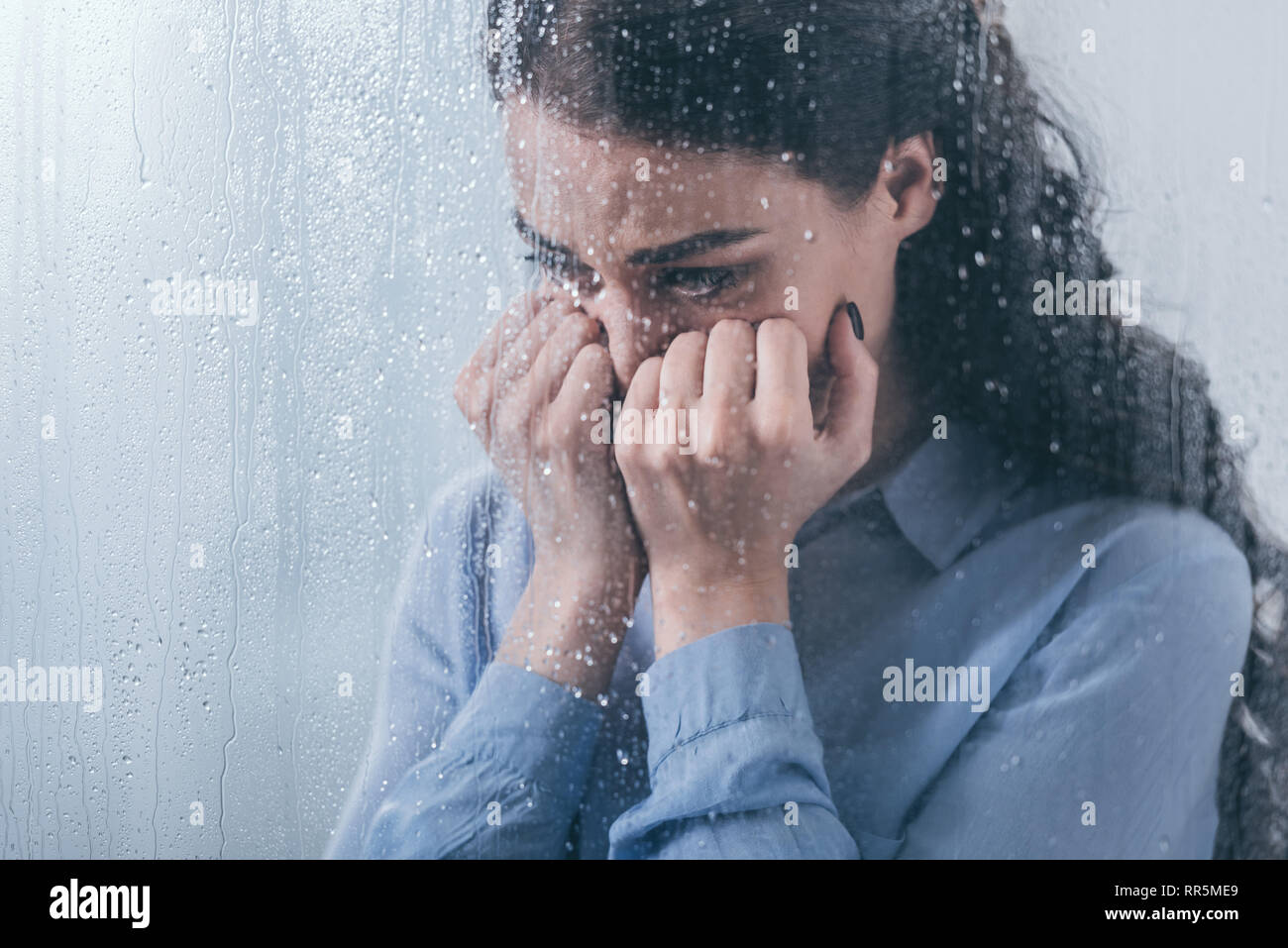 depressed woman covering face with hands and crying at home through ...