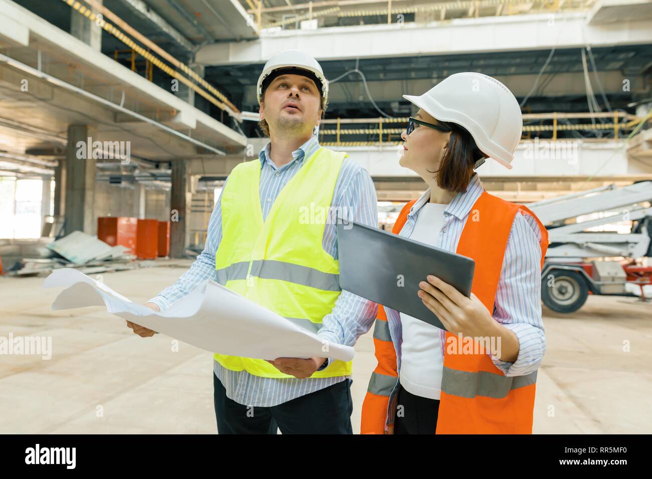 Building workers working at construction site, builders looking in ...