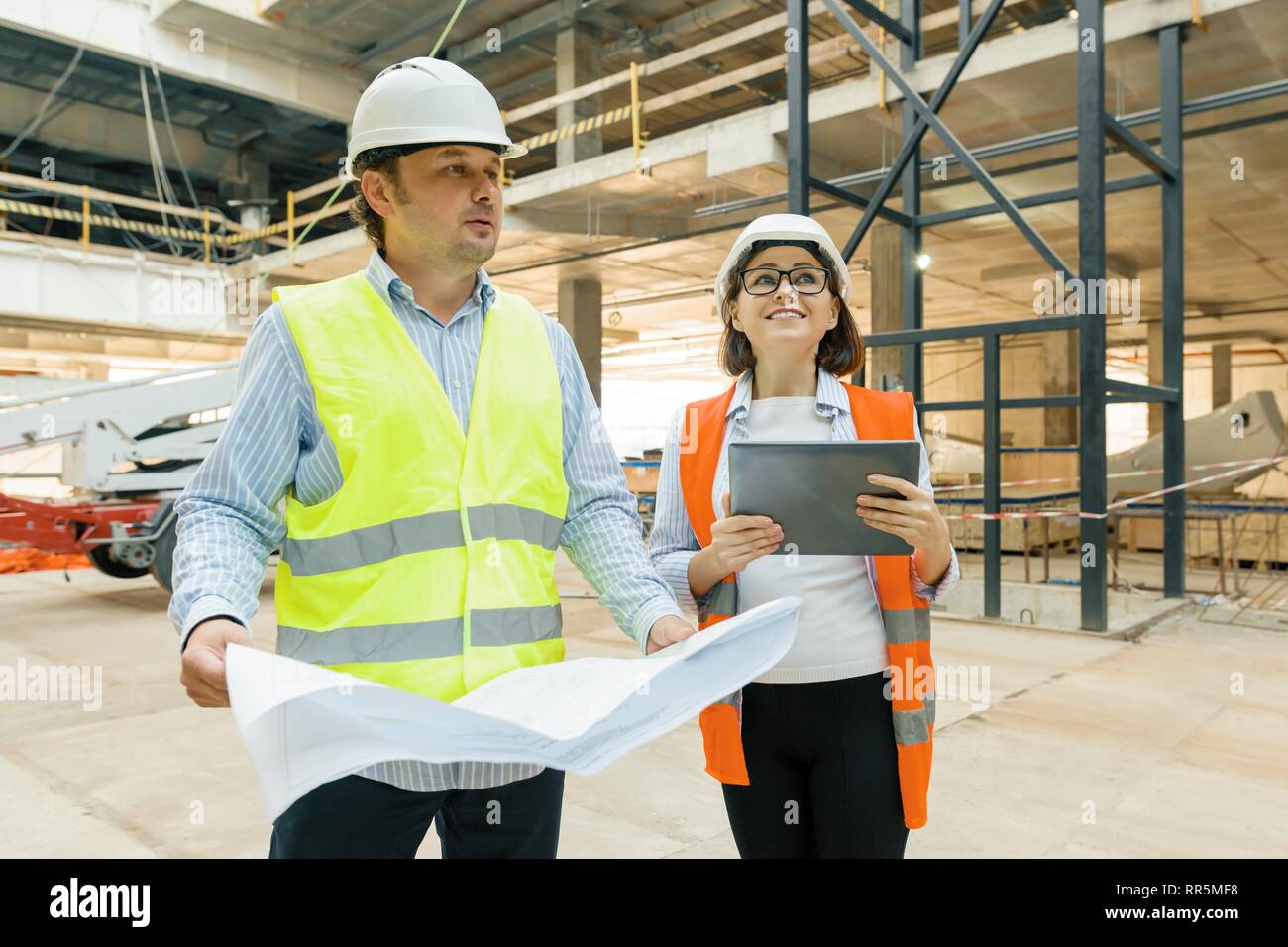 Male building workers working at construction site, builders looking in ...