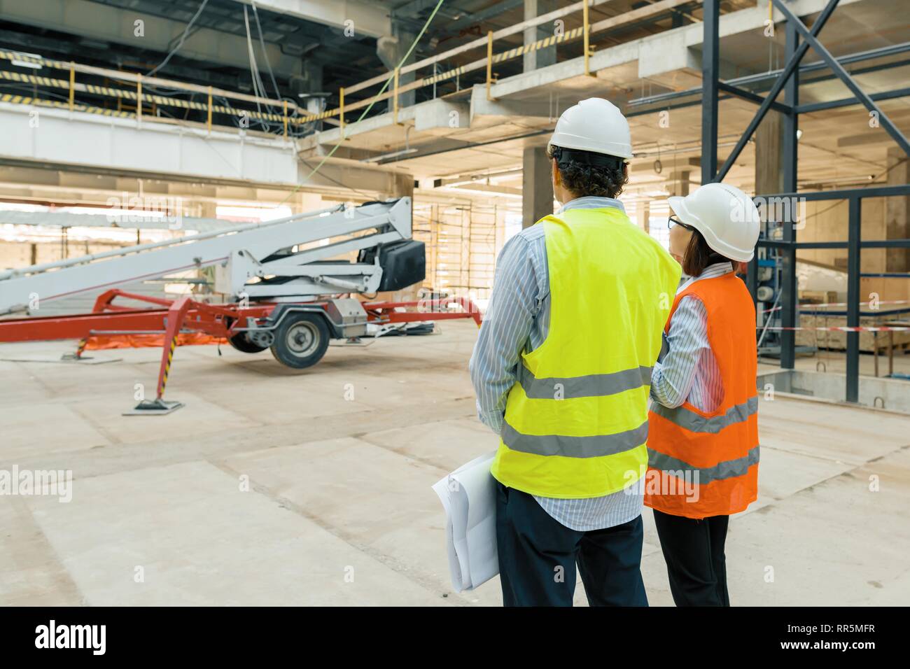 Building workers working at construction site, builders looking in ...