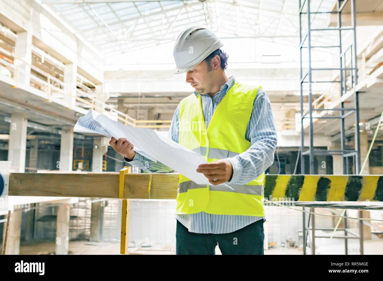 Portrait of confident male builder, manager, engineer with building ...