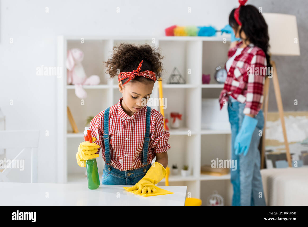 selective focus of cute african american child cleaning table while ...
