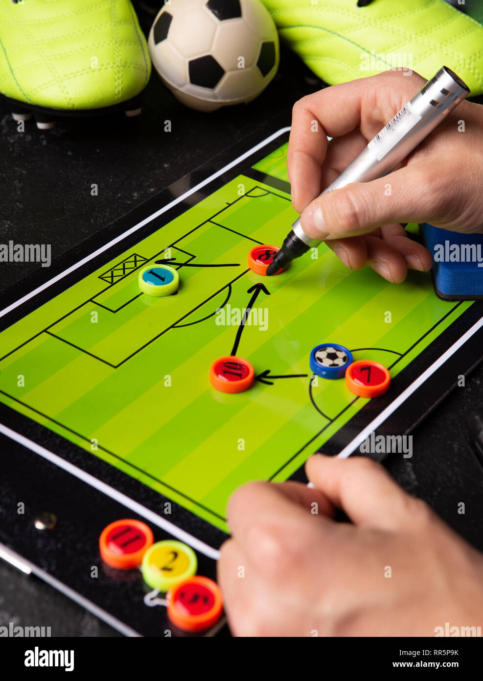 Photo of table football, soccer ball, boots, human hands with marker ...