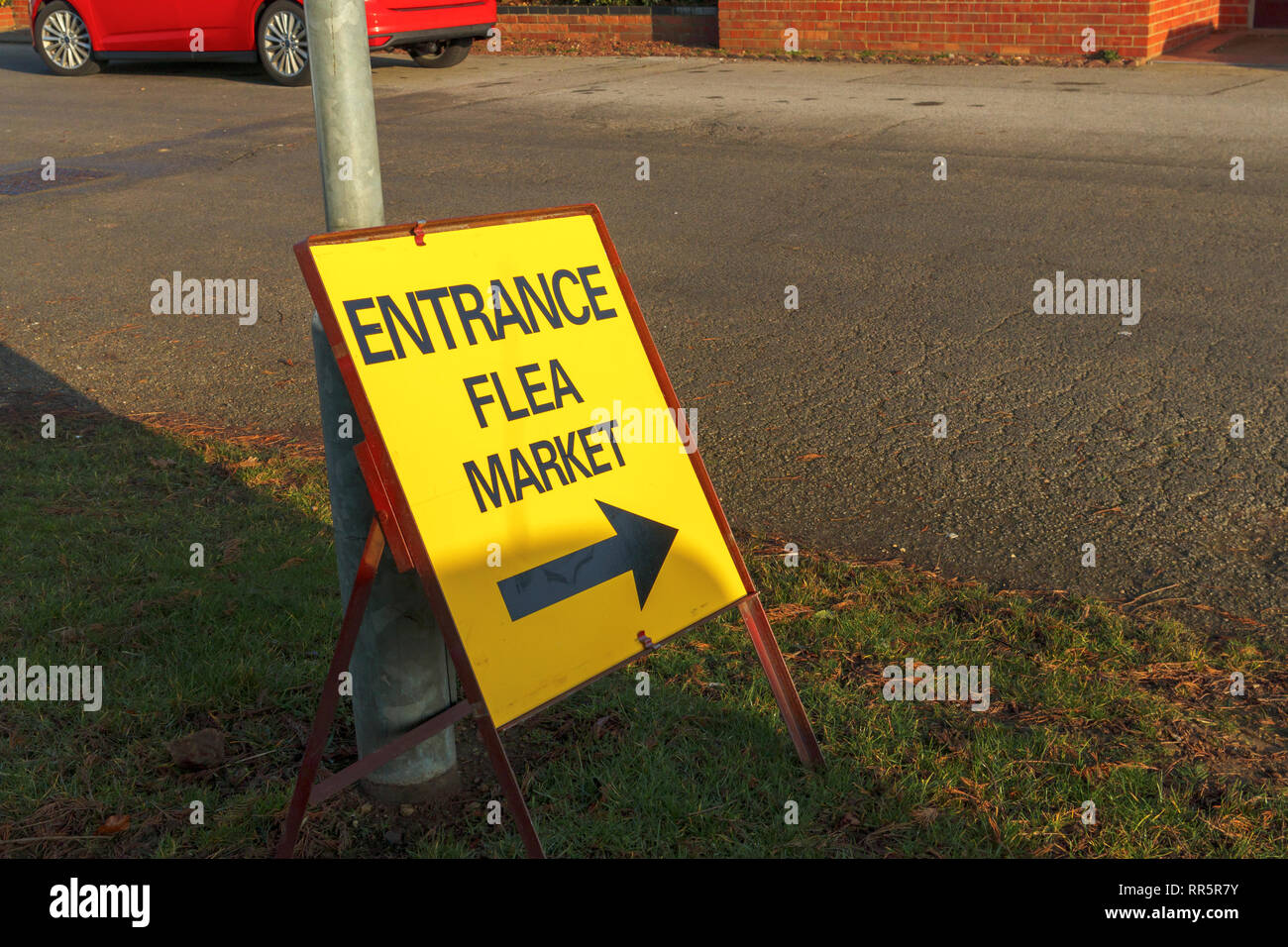 Yellow temporary entrance sign with direction arrow to a flea market ...