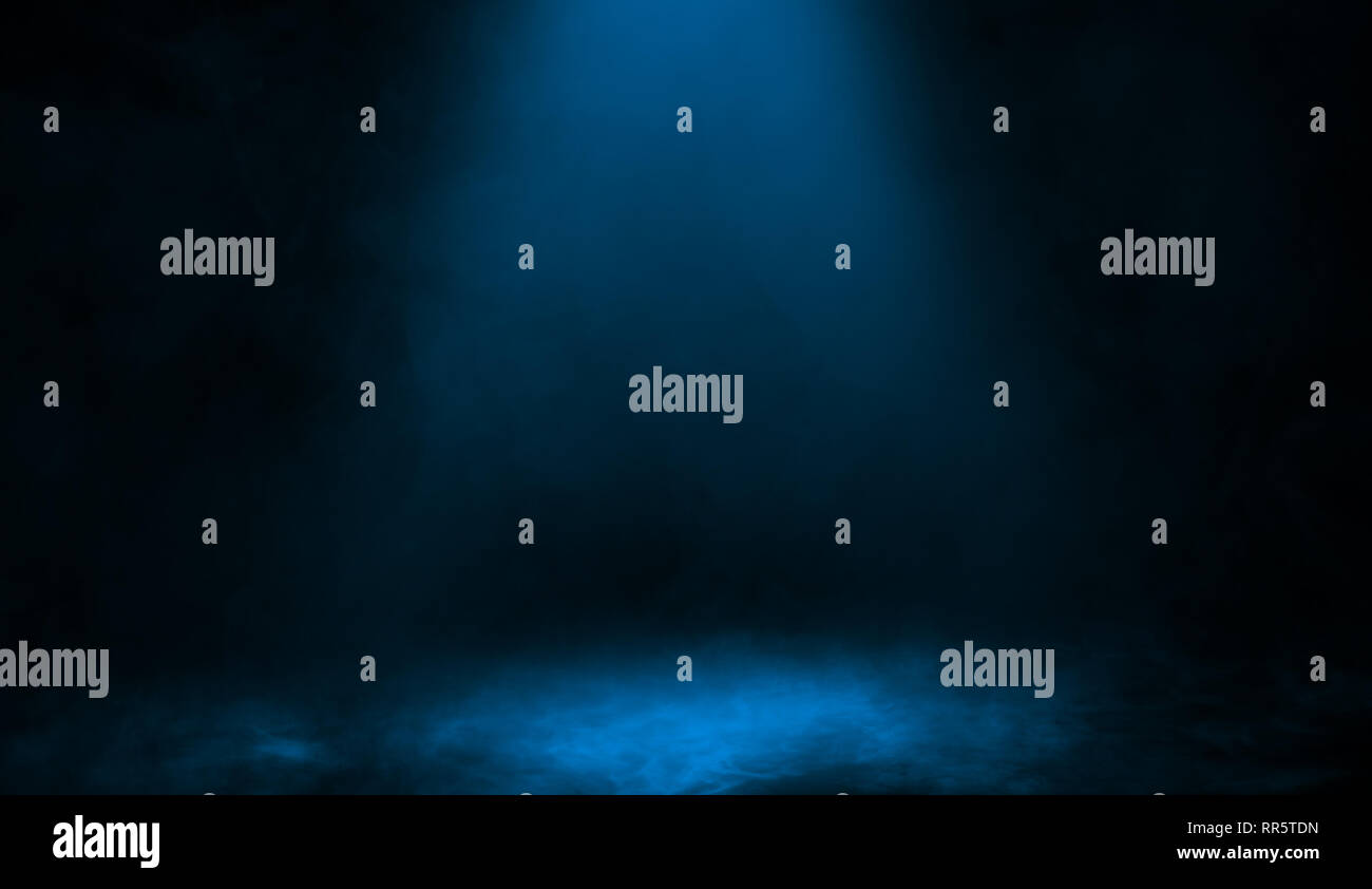 Abstract blue spotlight with smoke mist fog on a black background ...