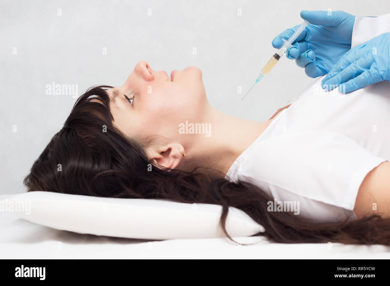The doctor makes plasma-lifting injection to the girl in the neck ...