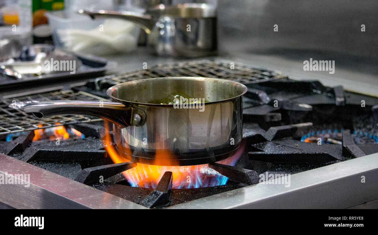 Chef cooking food, Preparation of soup in silver pan on gas ...