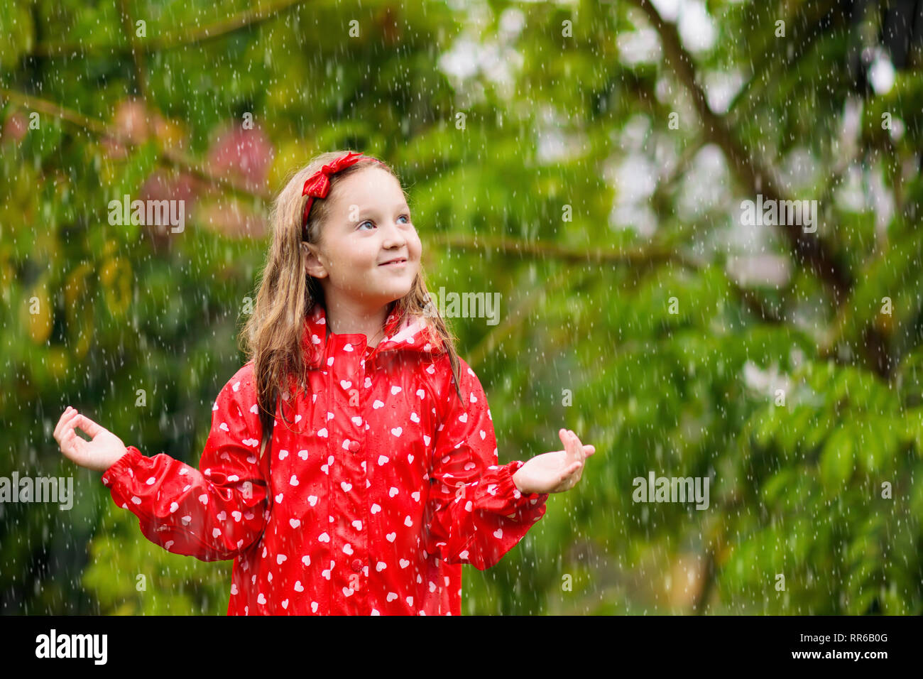Kids play in autumn rain. Child playing outdoor on rainy day. Little ...