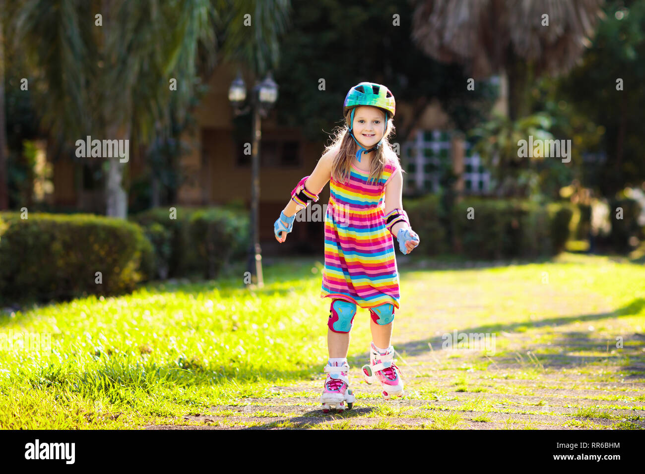 Child on inline skates in park. Kids learn to skate roller blades ...